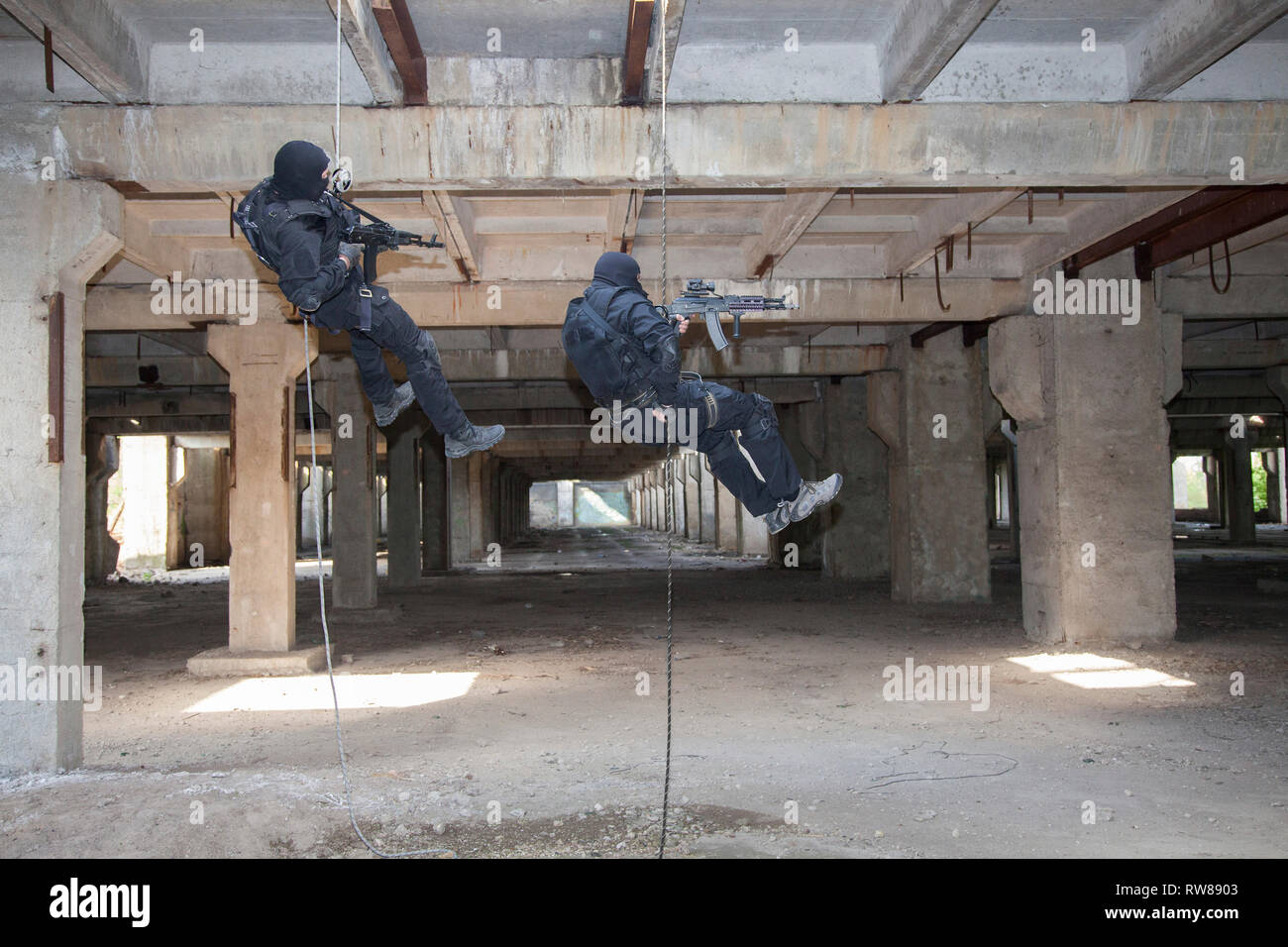 Special forces operators during assault rappelling with weapons Stock ...