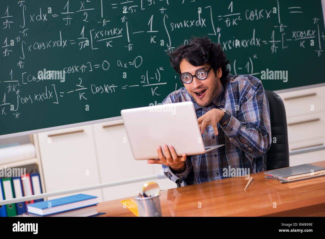 Funny male math teacher in the classroom Stock Photo - Alamy