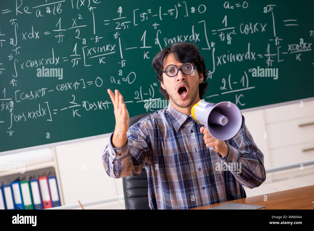 Funny male math teacher in the classroom Stock Photo - Alamy