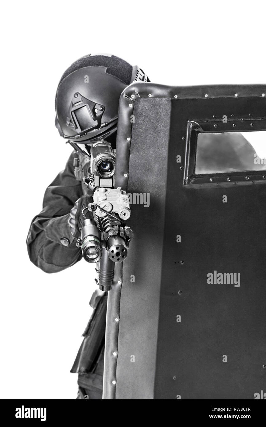 Studio shot of SWAT police special forces with rifle hiding behind ...