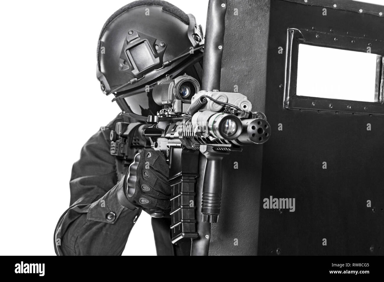 Studio shot of SWAT police special forces with rifle hiding behind ...