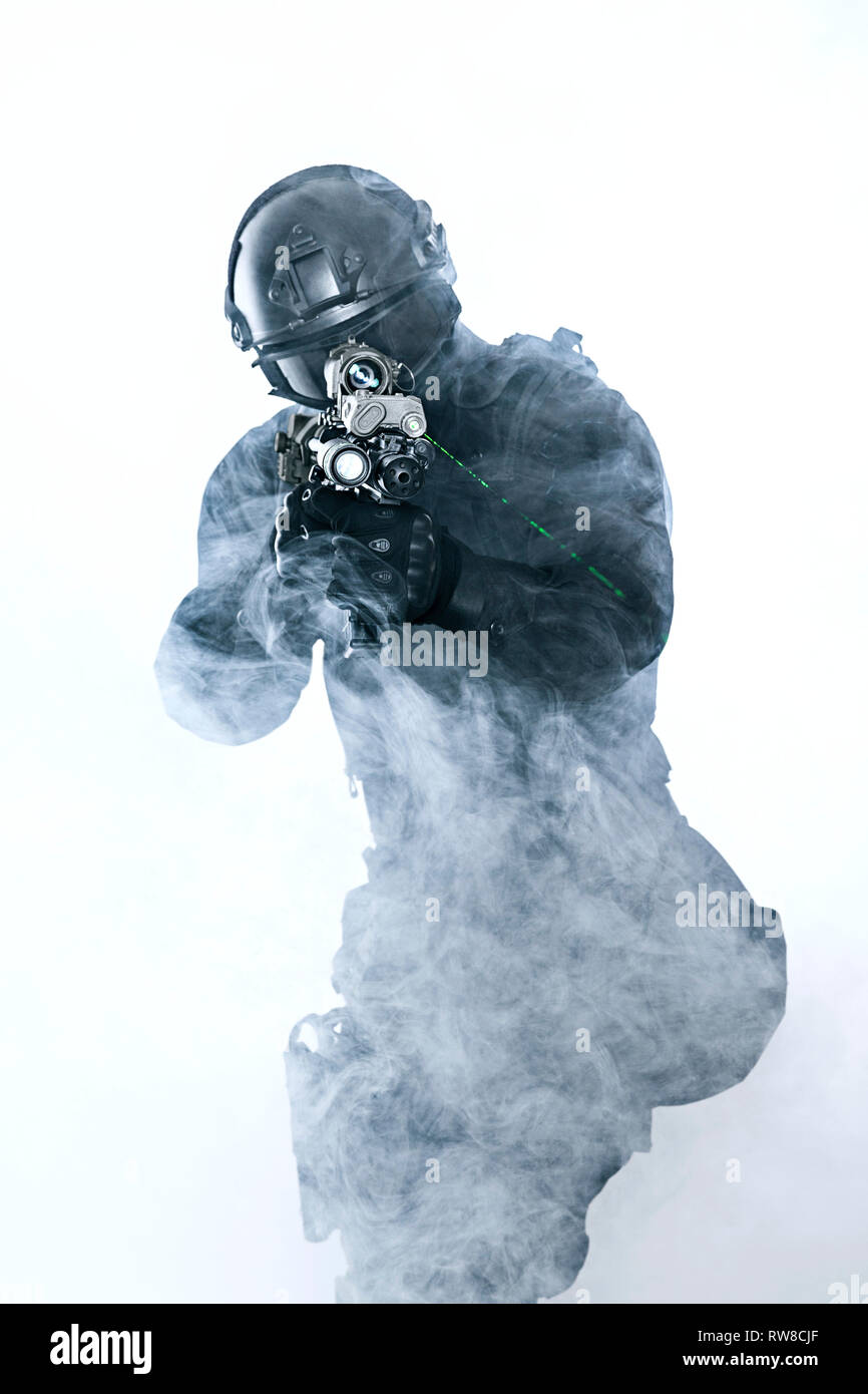 Studio shot of SWAT police special forces with automatic rifle pointing ...