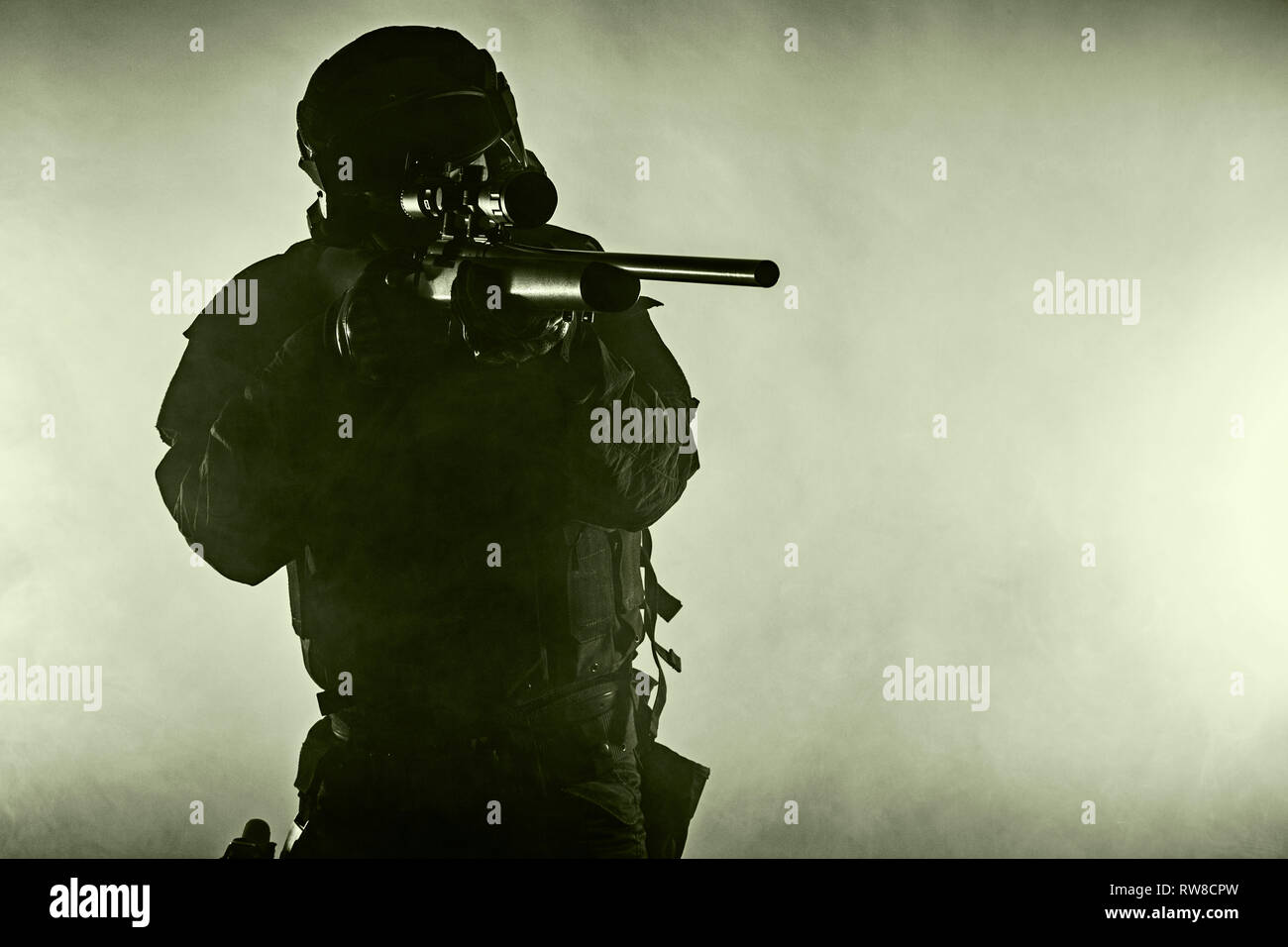 Studio shot of SWAT police operator with sniper rifle. Fire smoke ...