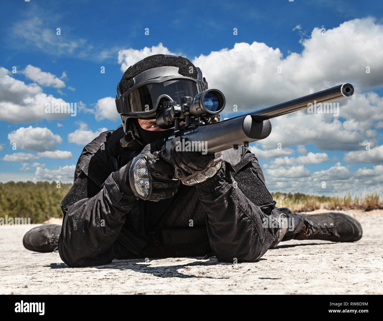 Low angle view of a SWAT police operator with sniper rifle, waiting in ...