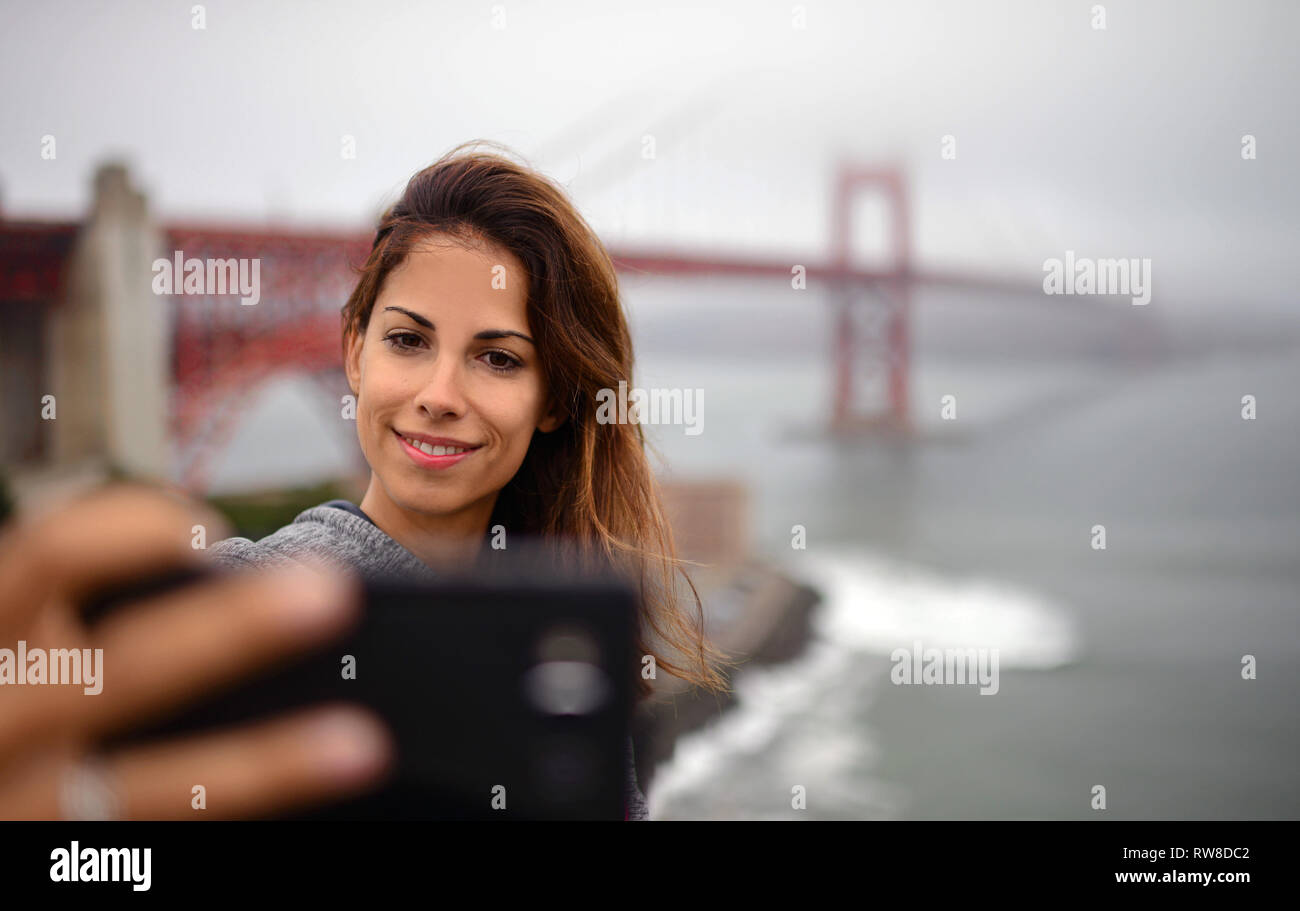 Young woman takes a selfie with Golden Gate Bridge, San Francisco Stock ...