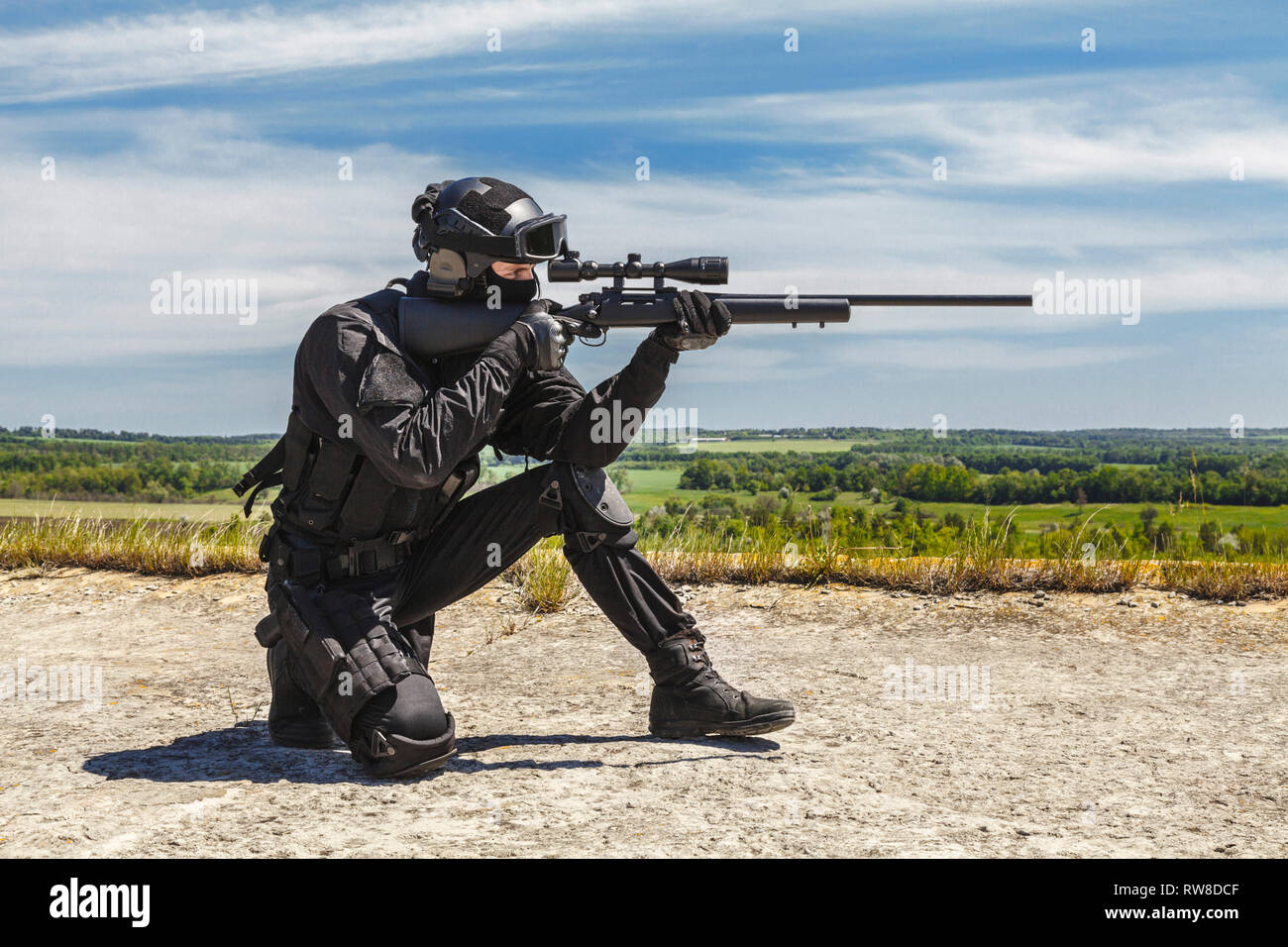 SWAT police operator with sniper rifle kneeling on top of a roof Stock ...