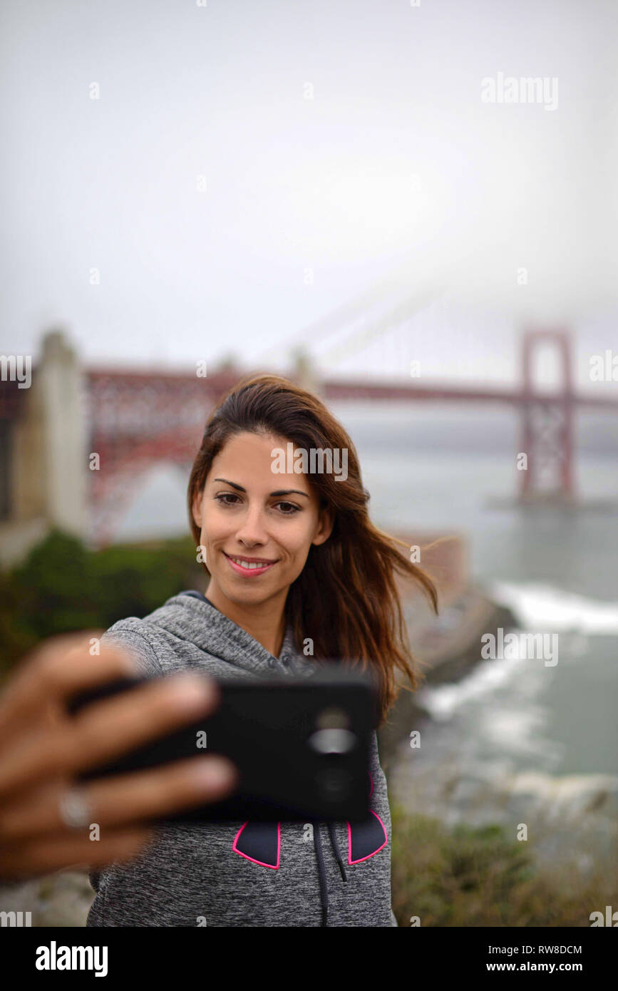 Young woman takes a selfie with Golden Gate Bridge, San Francisco Stock ...