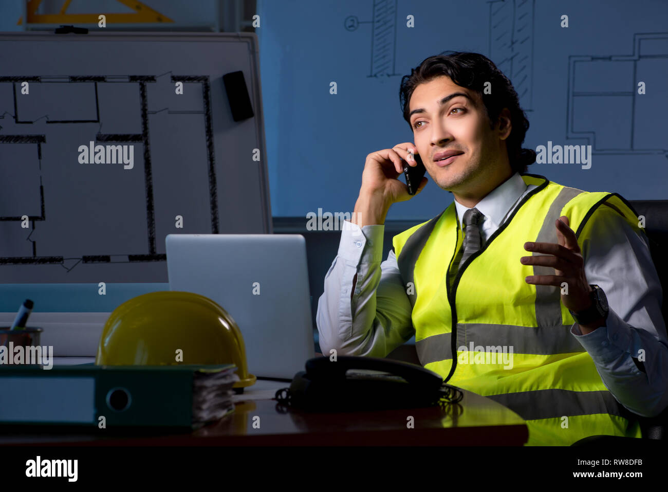 Young construction architect working on project at night Stock Photo ...