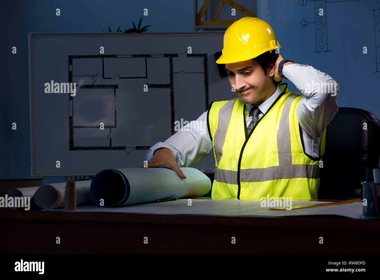 Young construction architect working on project at night Stock Photo ...