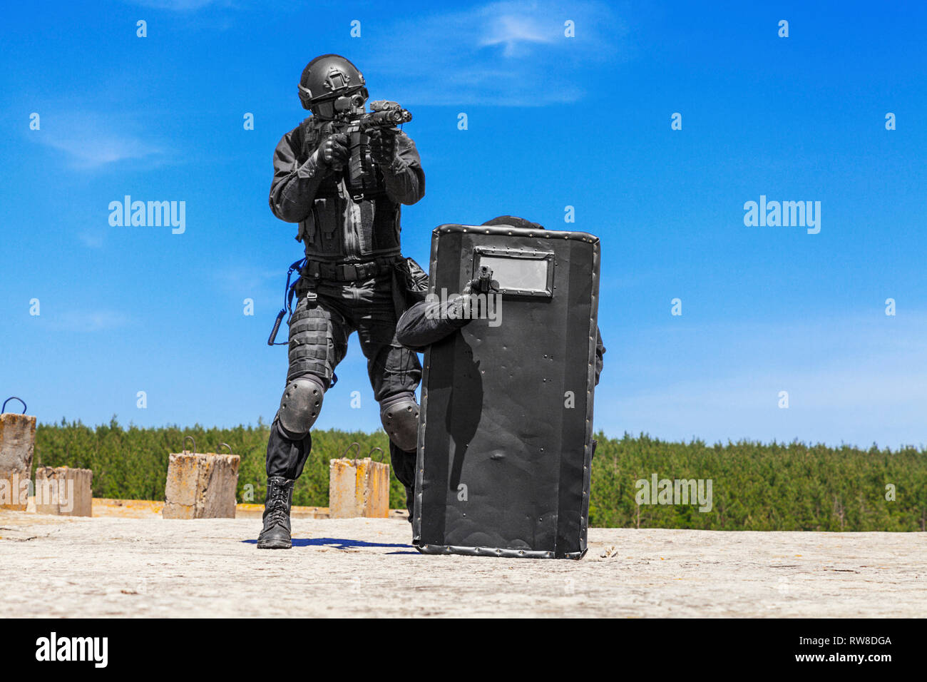 SWAT police special forces operators hiding behind ballistic shield ...