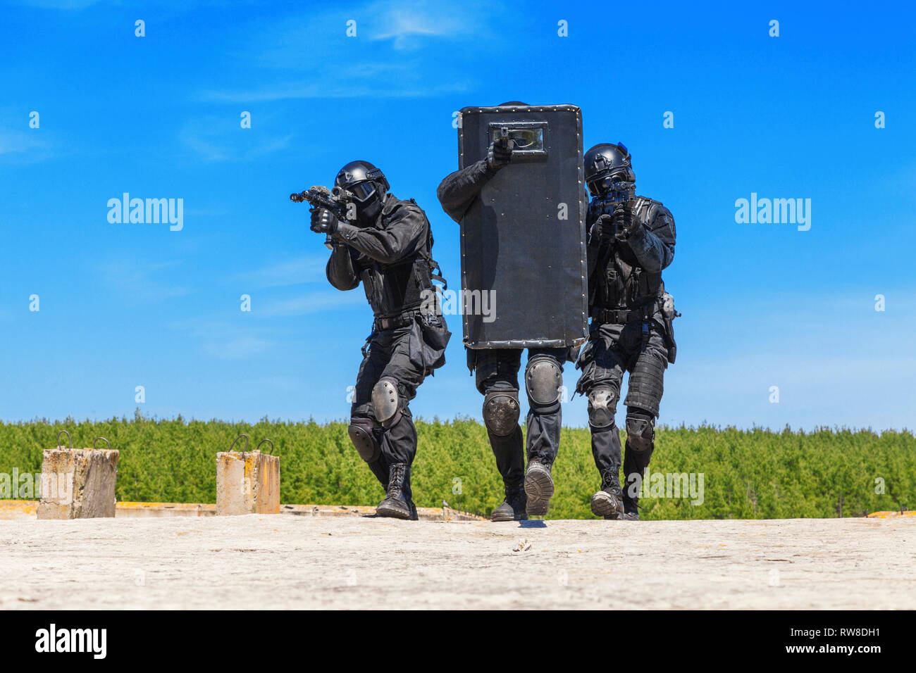 SWAT police special forces operators hiding behind ballistic shield ...