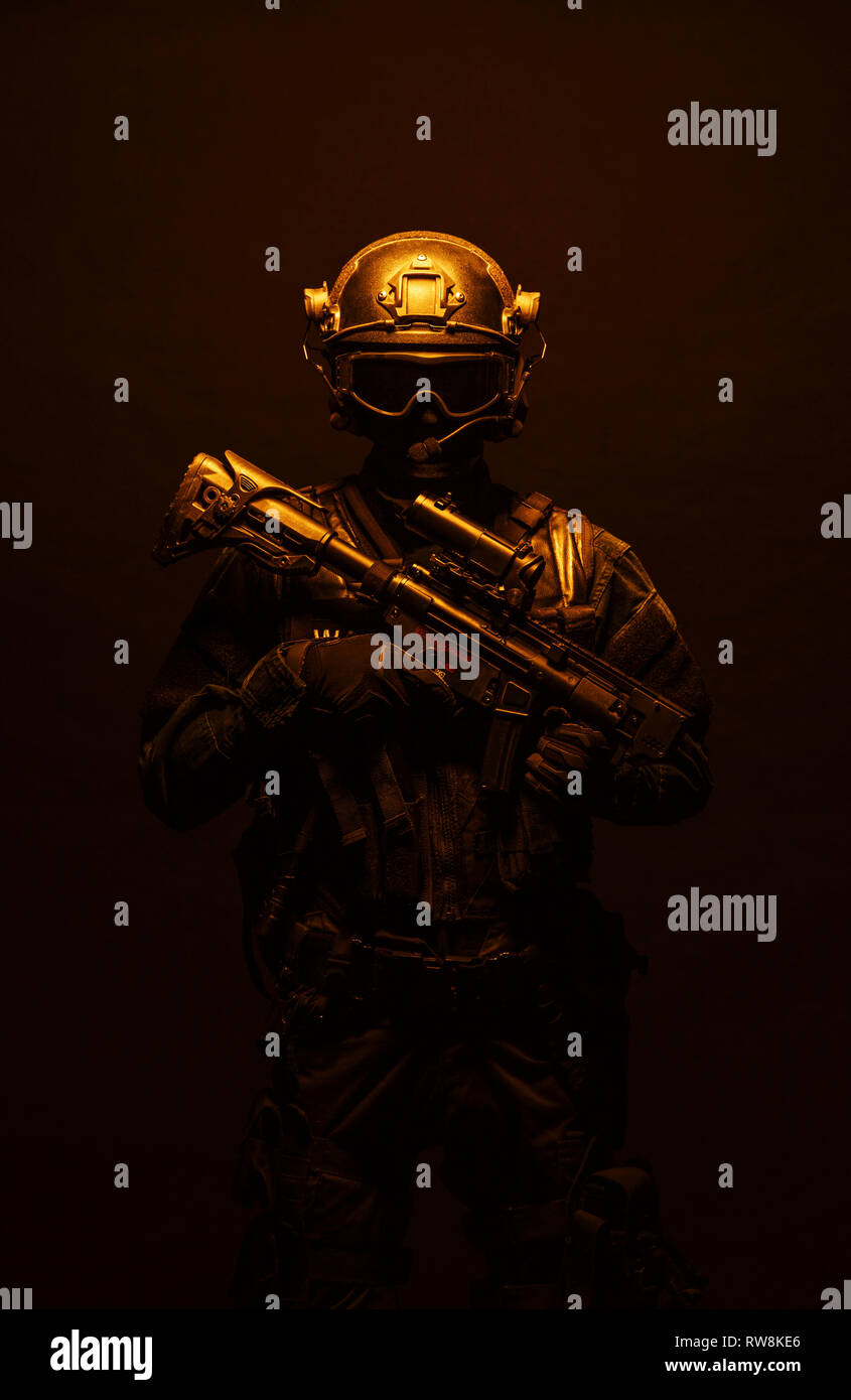 Spec ops police officer SWAT in black uniform and face mask, studio ...