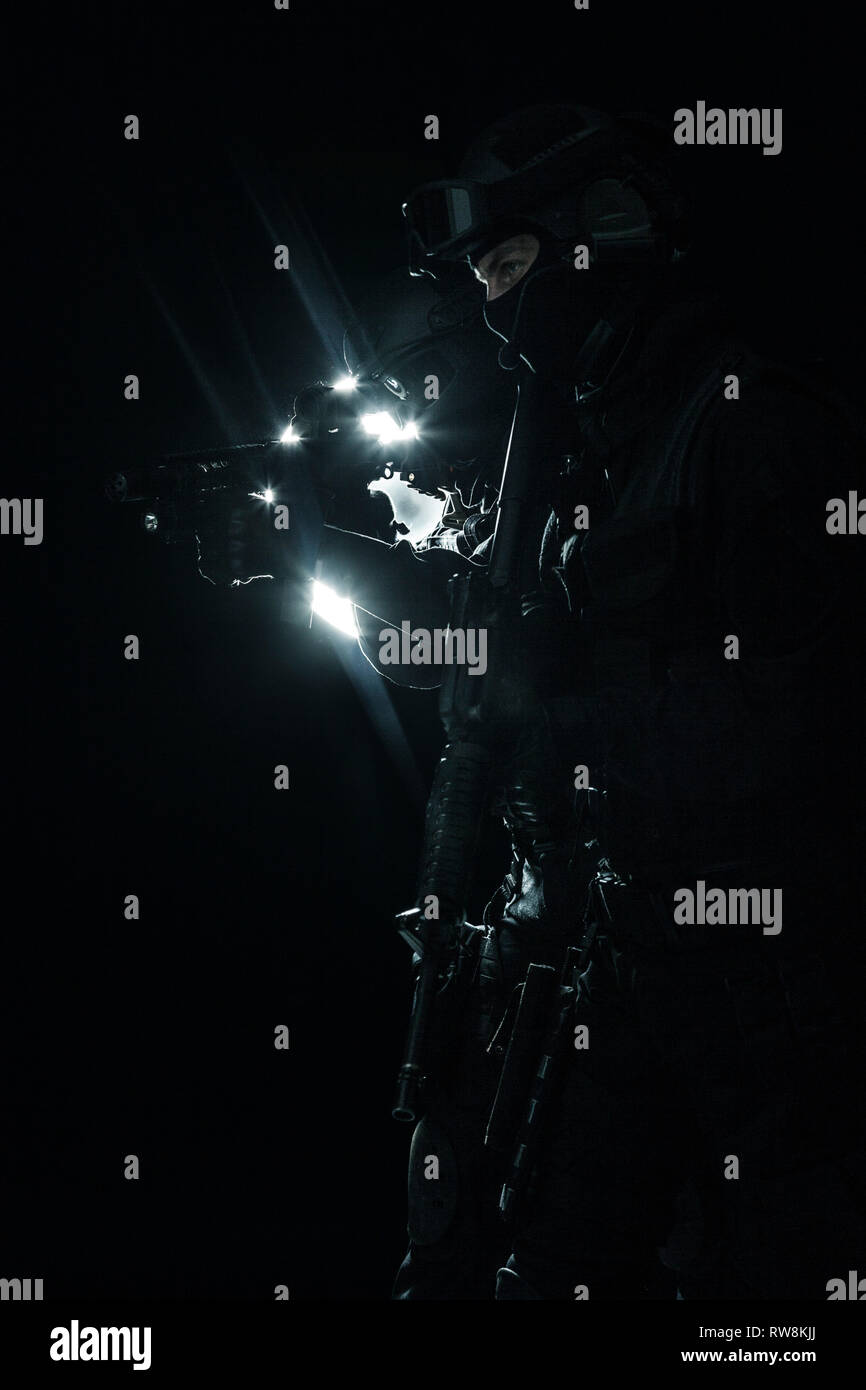 Spec ops police officers SWAT in black uniform and face mask, studio ...