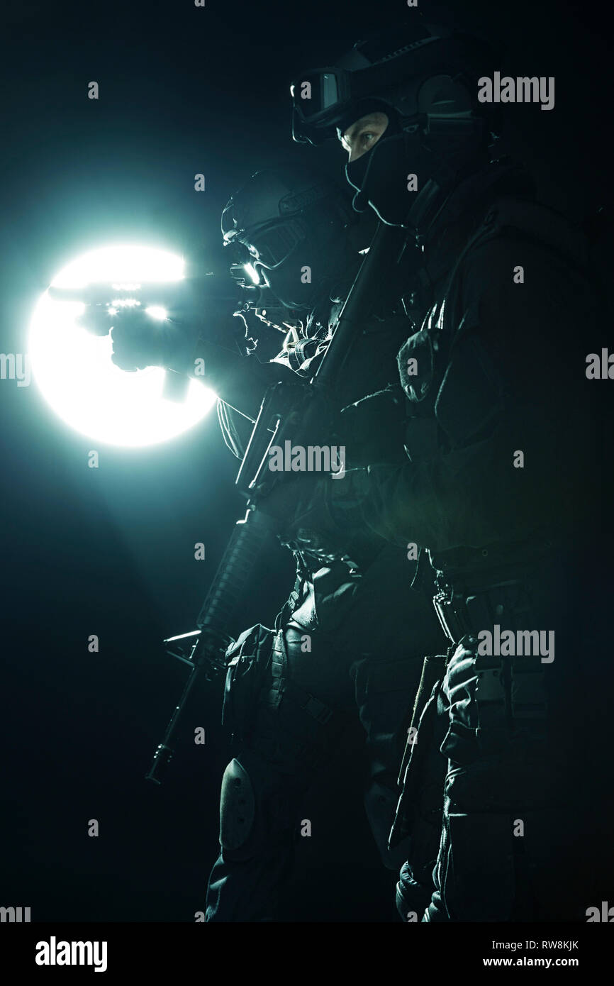 Spec ops police officers SWAT in black uniform and face mask, studio ...
