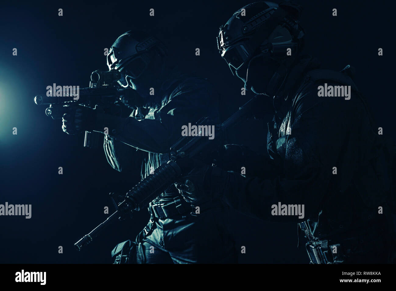 Spec ops police officers SWAT in black uniform and face mask, studio ...