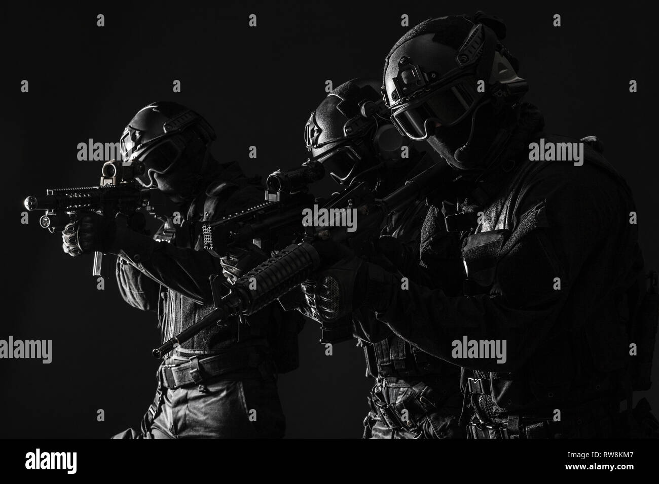 Spec ops police officers SWAT in black uniform and face mask, studio ...