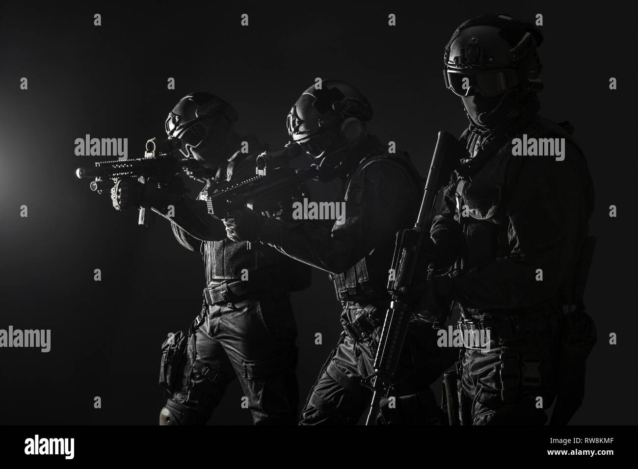 Spec ops police officers SWAT in black uniform and face mask, studio ...