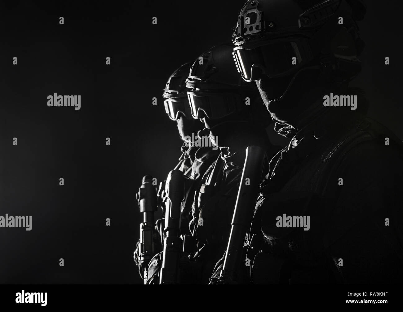 Spec ops police officers SWAT in black uniform and face mask, studio ...