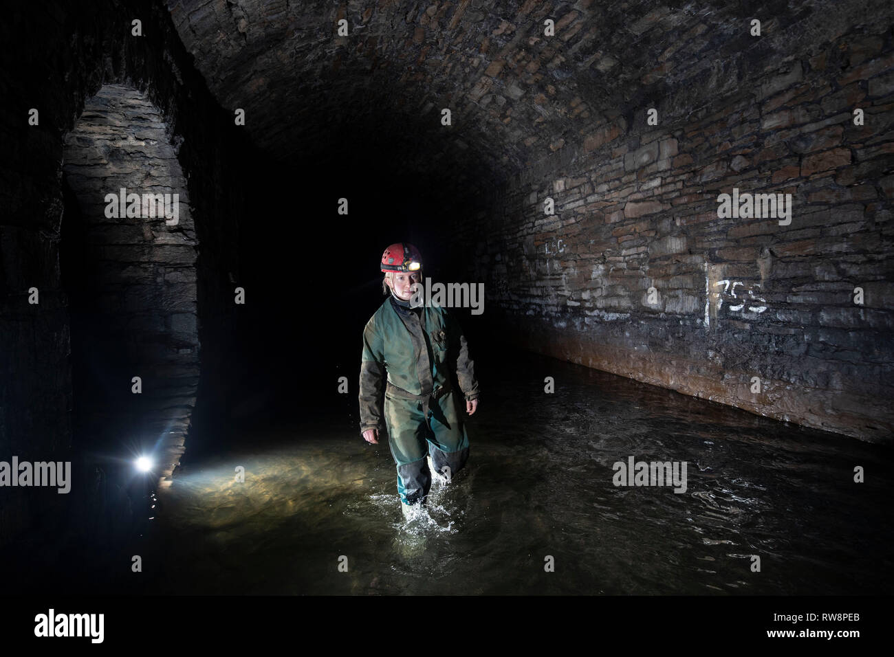 A woman urban caving as an underground network of rivers are opened up ...