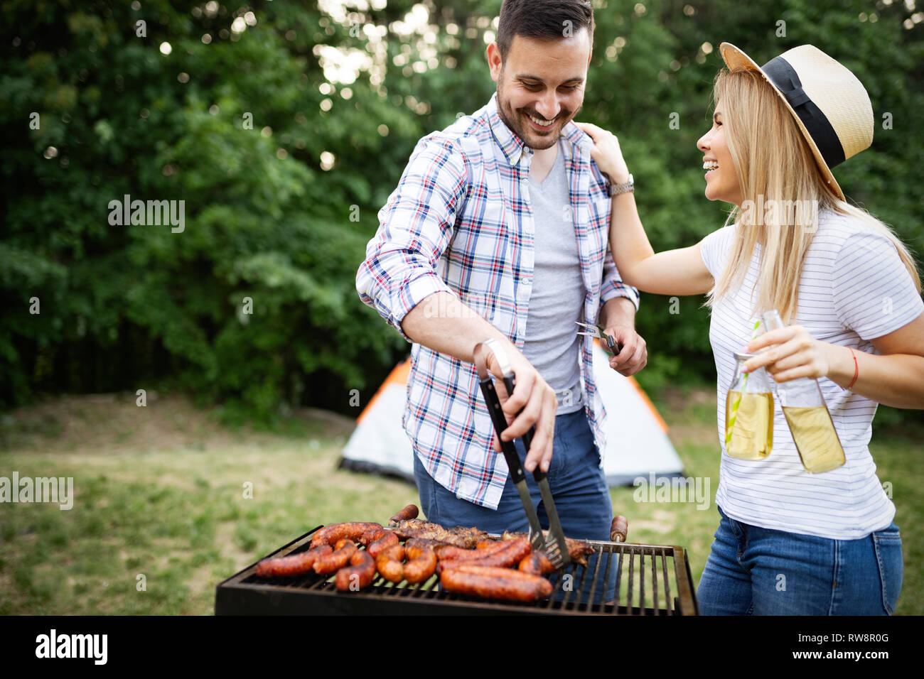 Friends having a barbecue party in nature while having fun Stock Photo ...
