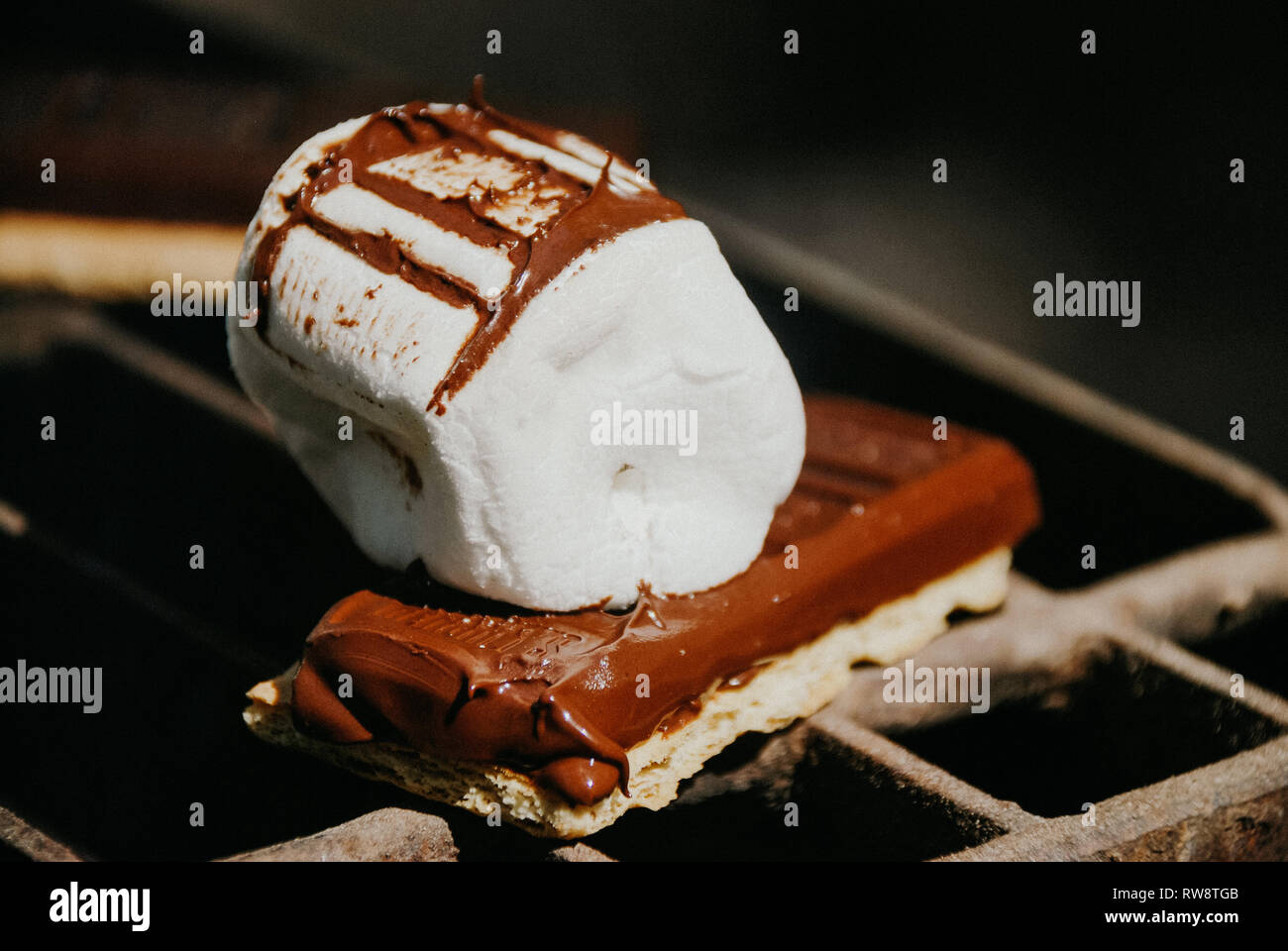 A marshmallow chocolate smore being cooked on a campground fire Stock ...