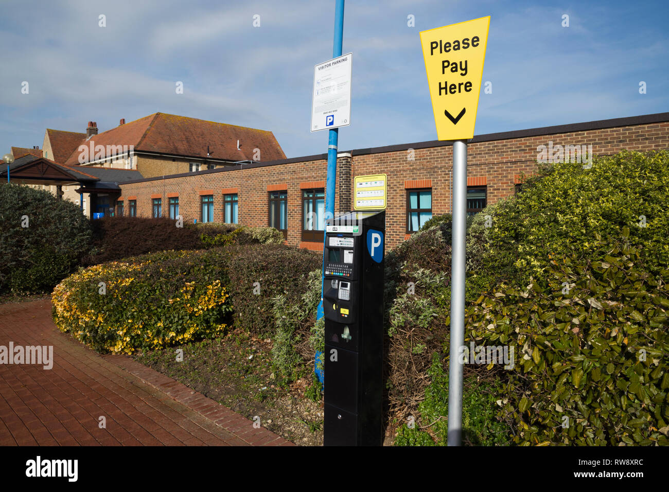 Pay and display ticket machine / pay point with Please Pay Here sign ...