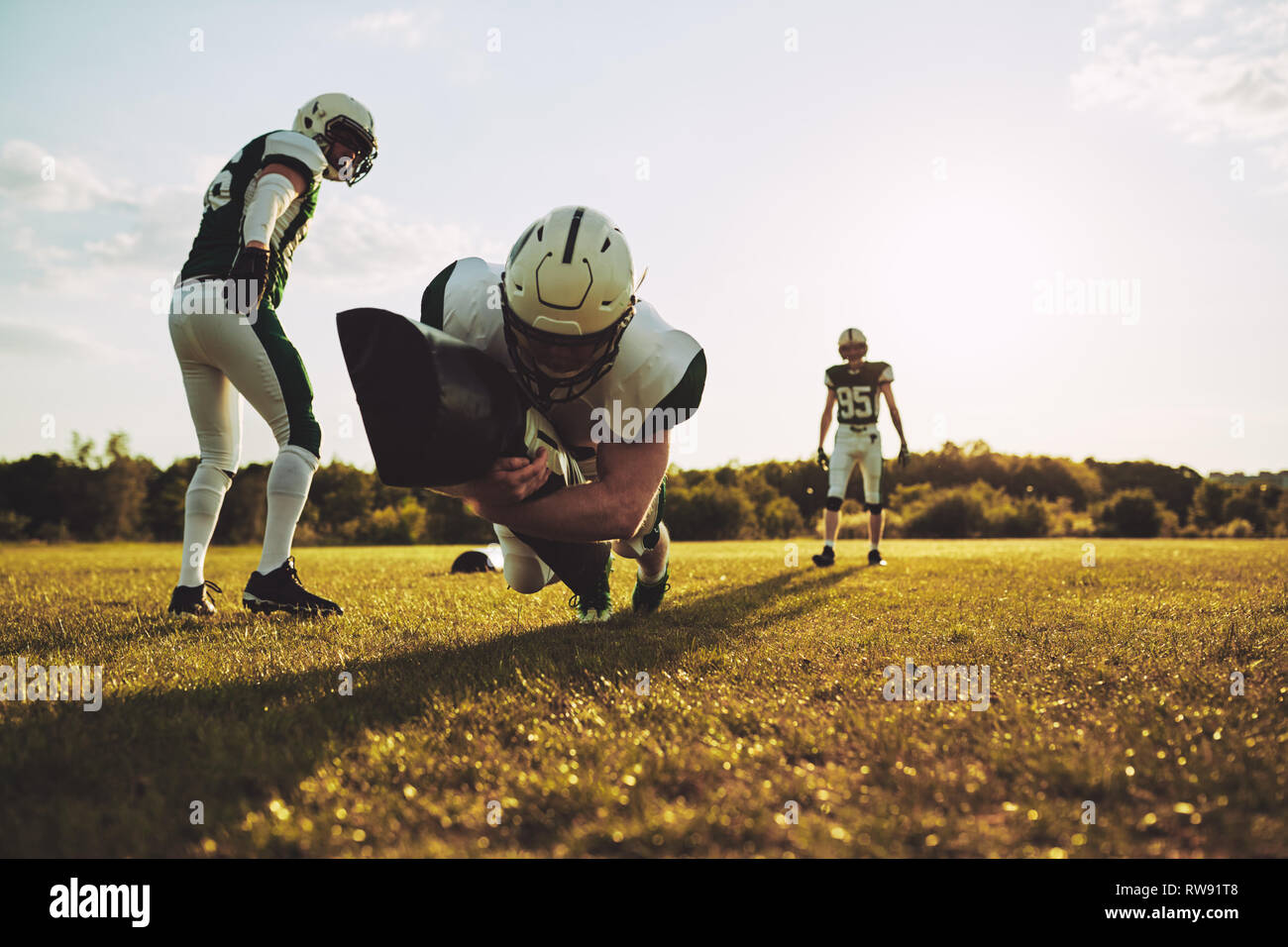 Group of young American football players practicing defence and tackles ...
