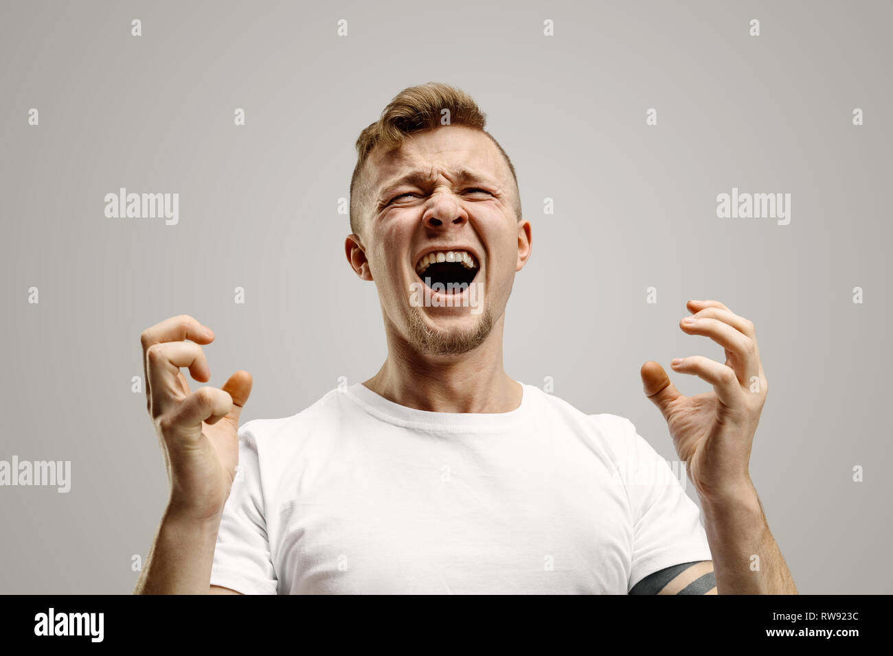 Screaming, hate, rage. Crying emotional angry man screaming on gray ...