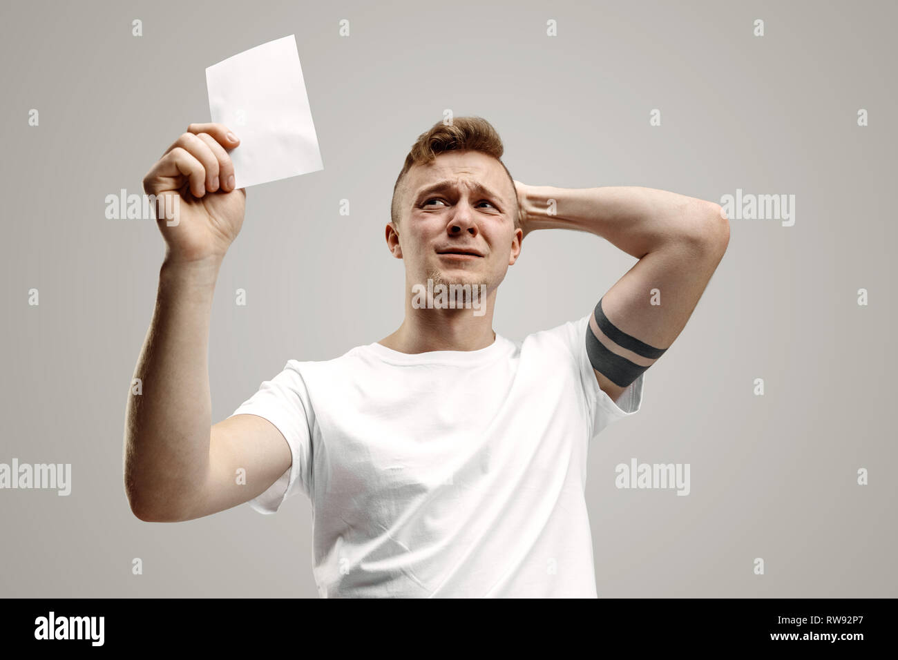 Young caucasian man with a surprised happy expression won a bet on gray ...