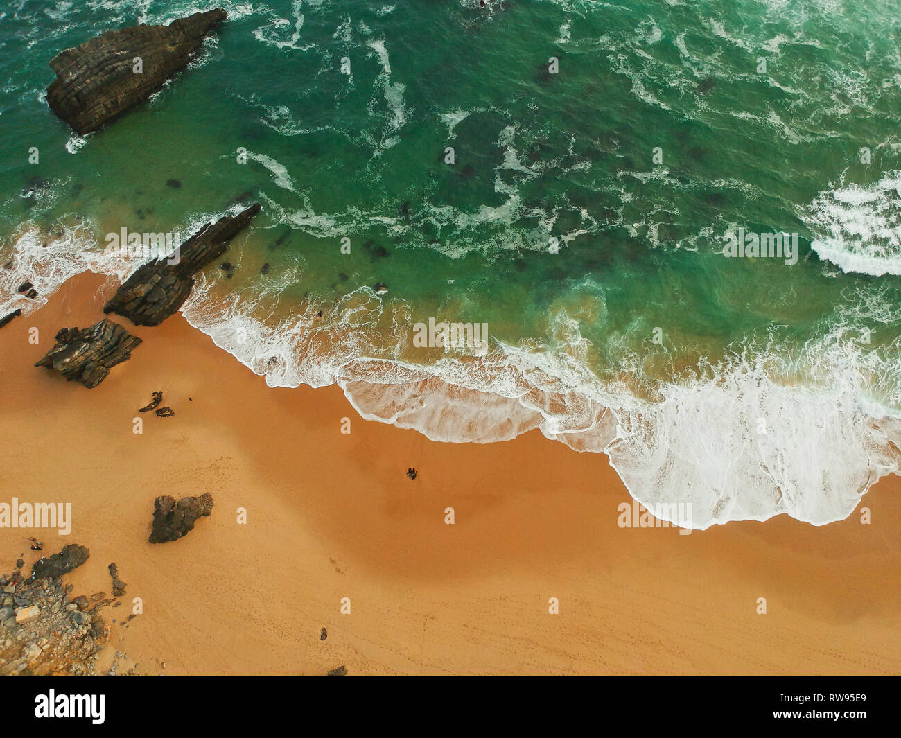 Top view of a beautiful sandy beach aerial shot with the waves rolling ...