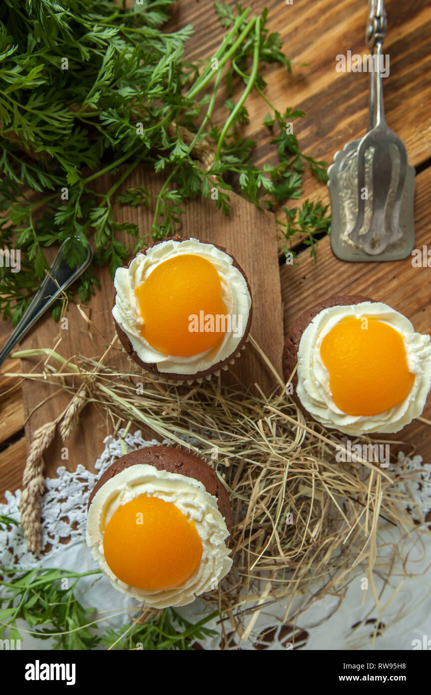 Easter cupcake on wooden background with Peach looks like a fried egg ...