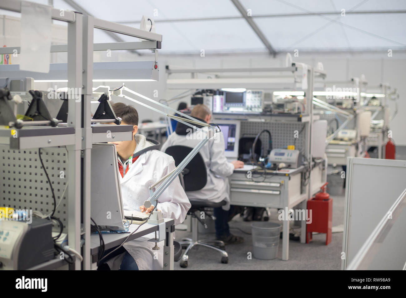 People wearing white coats sitting in the laboratory at the computers ...