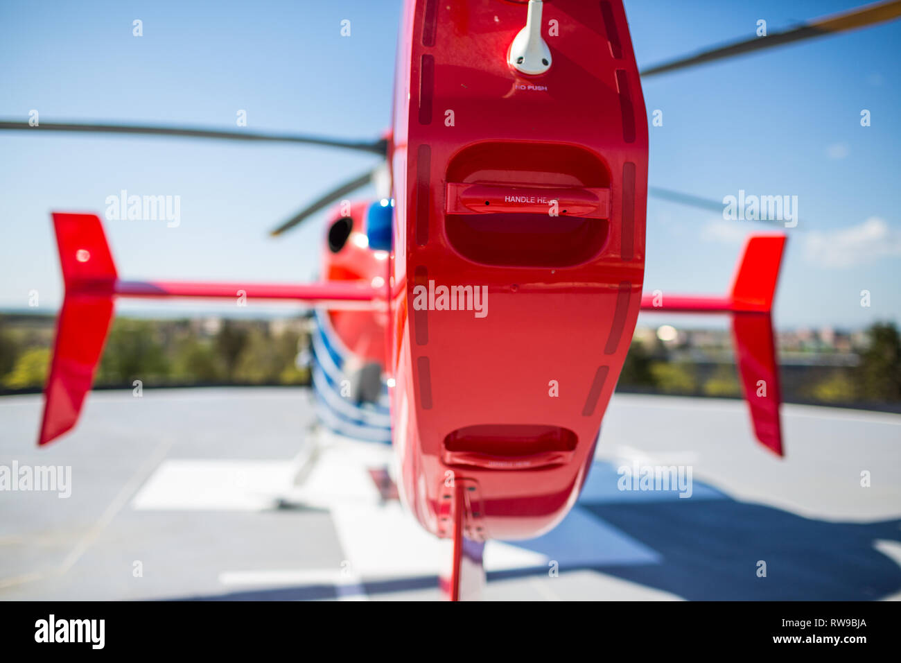 Modern medical helicopter on a hospital rooftop helipad from behind ...