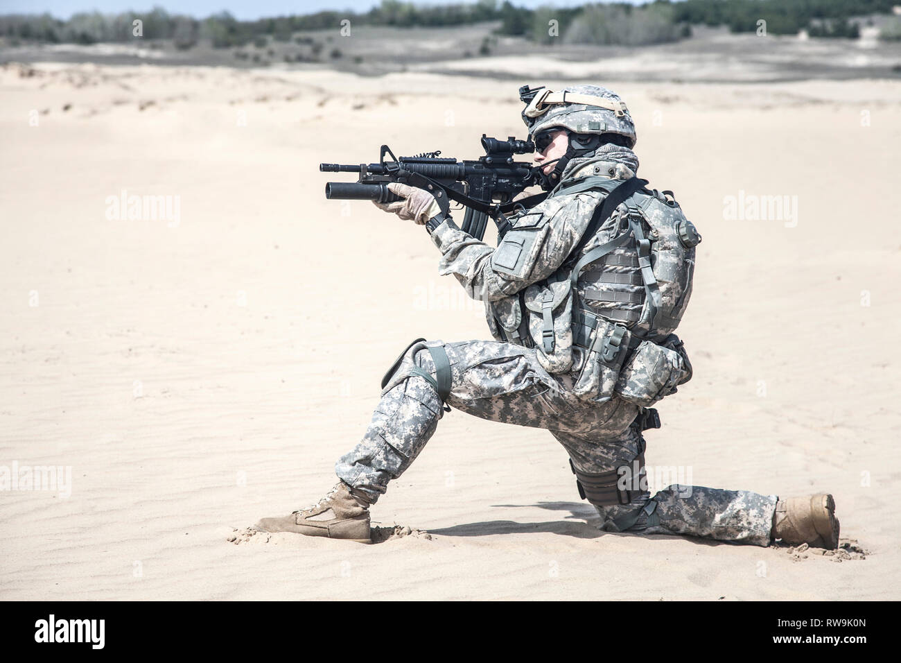 United States airborne infantry man in action in the desert, kneeling ...