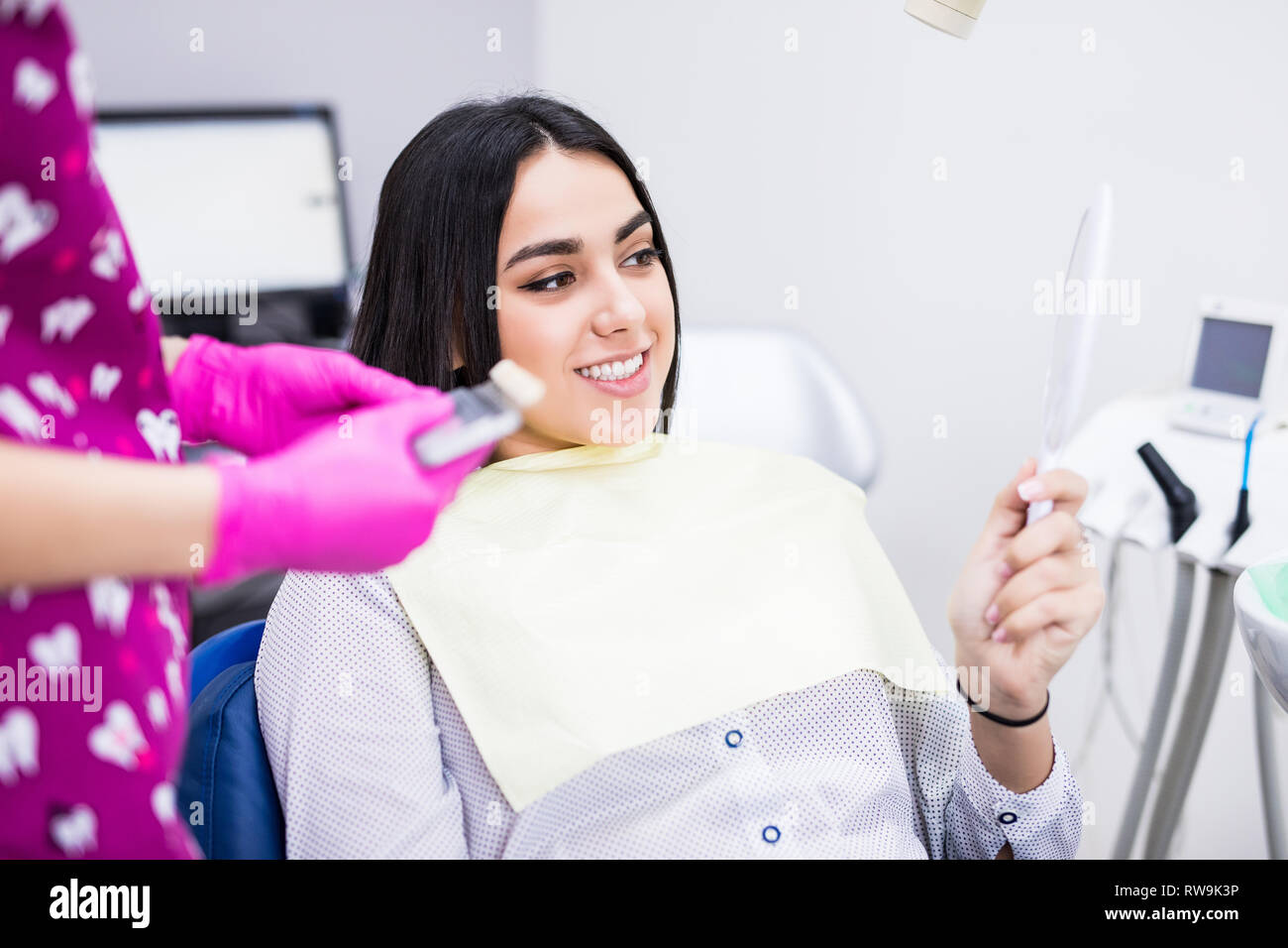 Beautiful young female patient with perfect white teeth sitting in ...