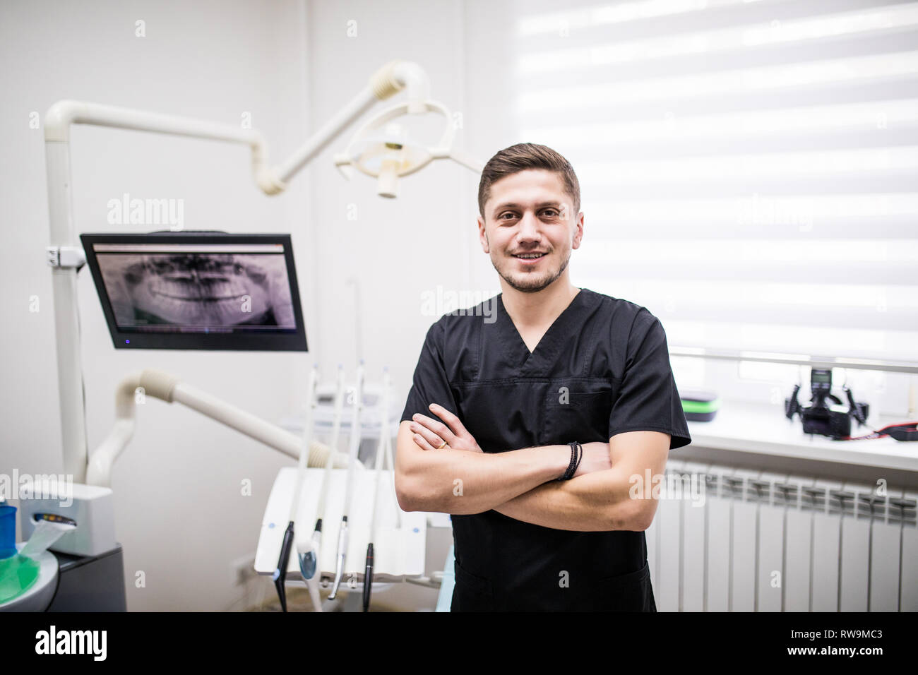 Dentist standing in examination room hi-res stock photography and ...