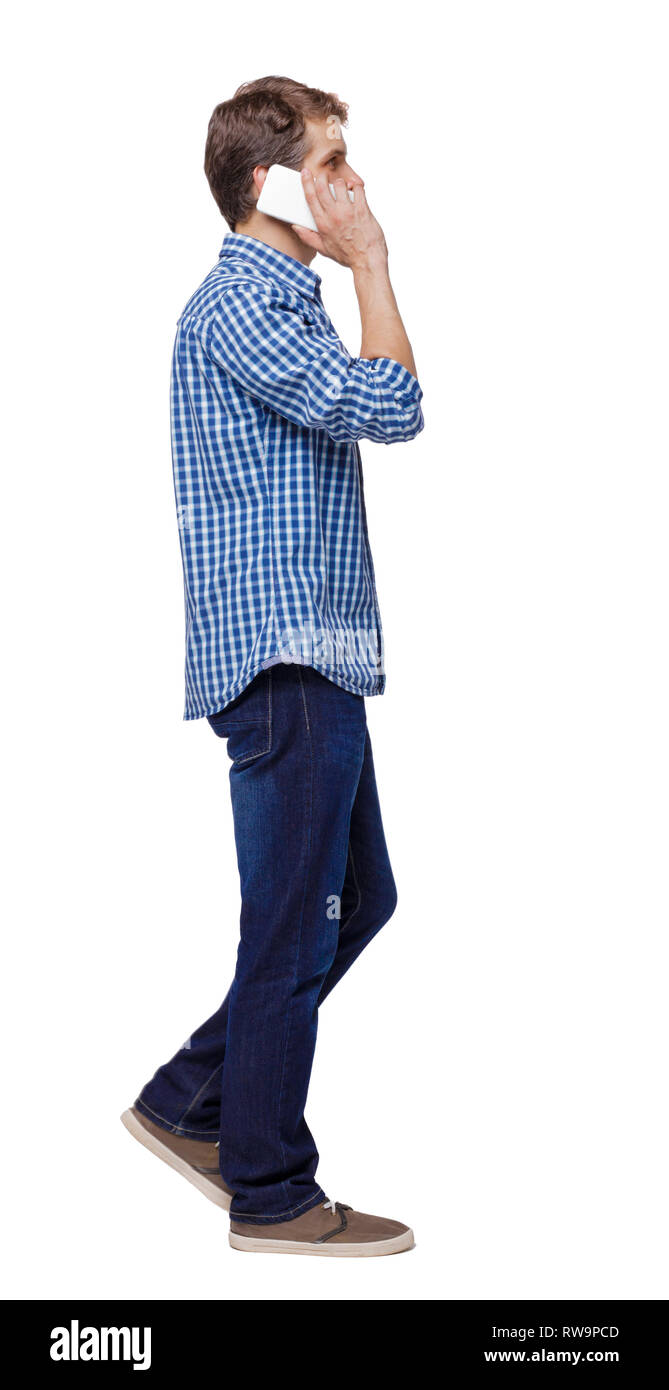 side view of man walking with a mobile phone. backside view of person ...