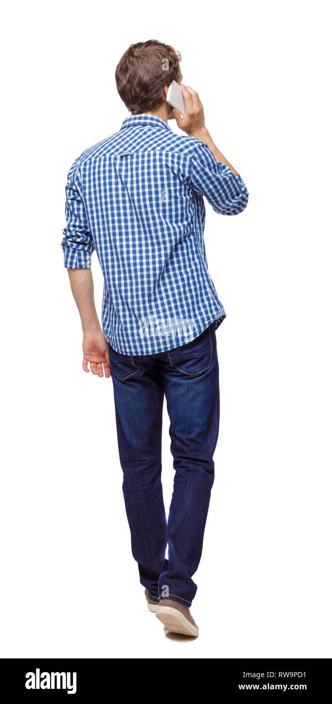 backview of man walking with a mobile phone. backside view of person ...