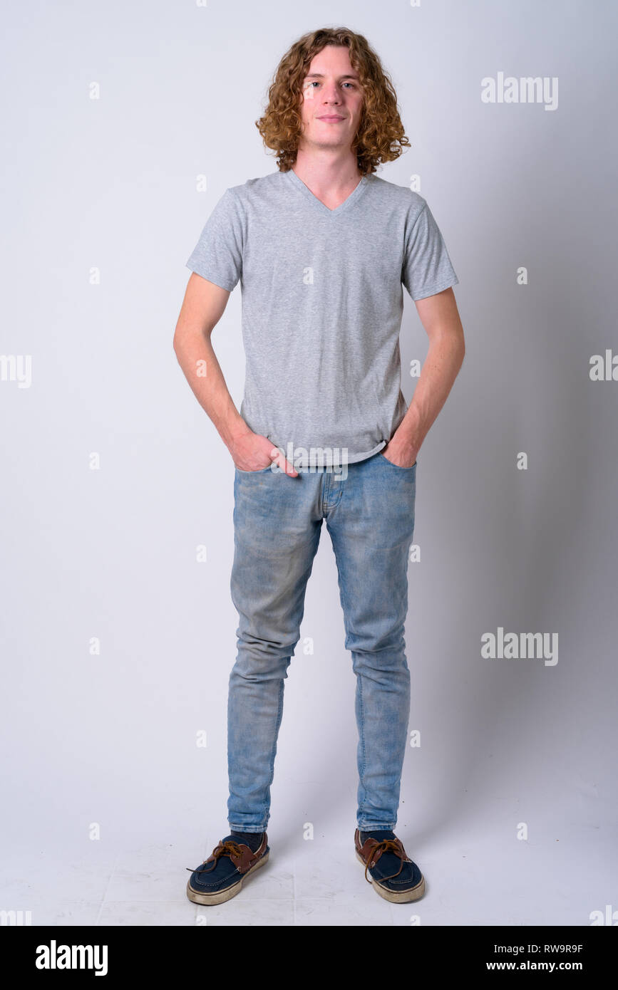 Full body shot of young handsome man with curly hair Stock Photo - Alamy