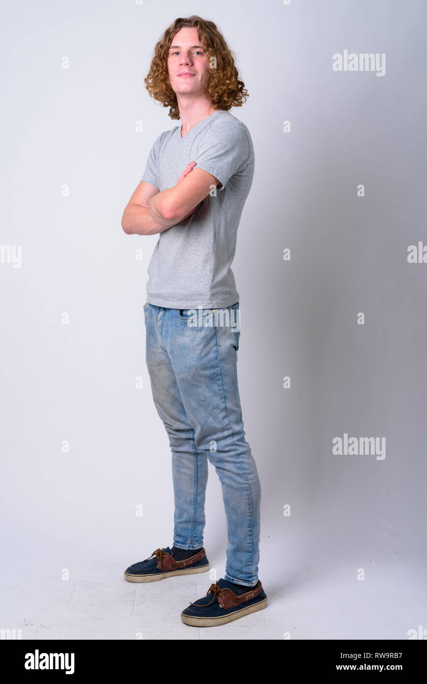 Full body shot profile view of young handsome man looking at camera ...