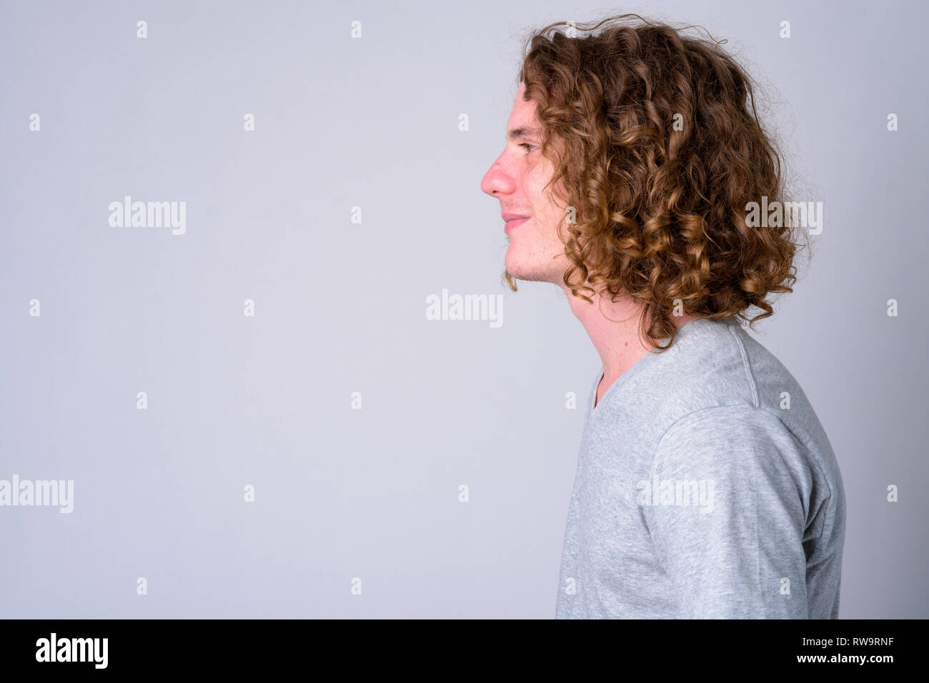 Closeup profile view of young handsome man with curly hair Stock Photo ...