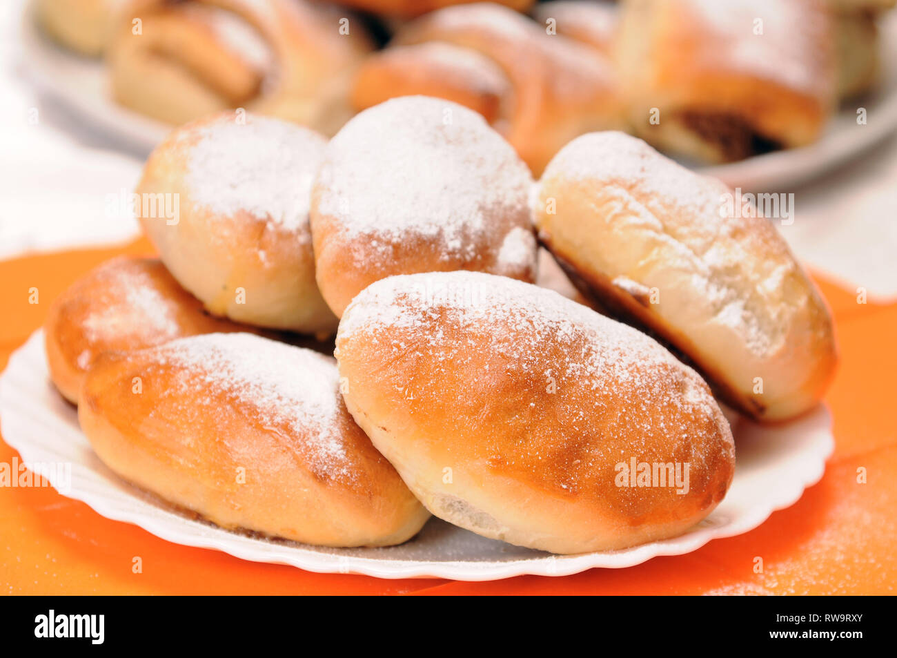 a stack of buns sprinkled with sugar on a white plate Stock Photo - Alamy