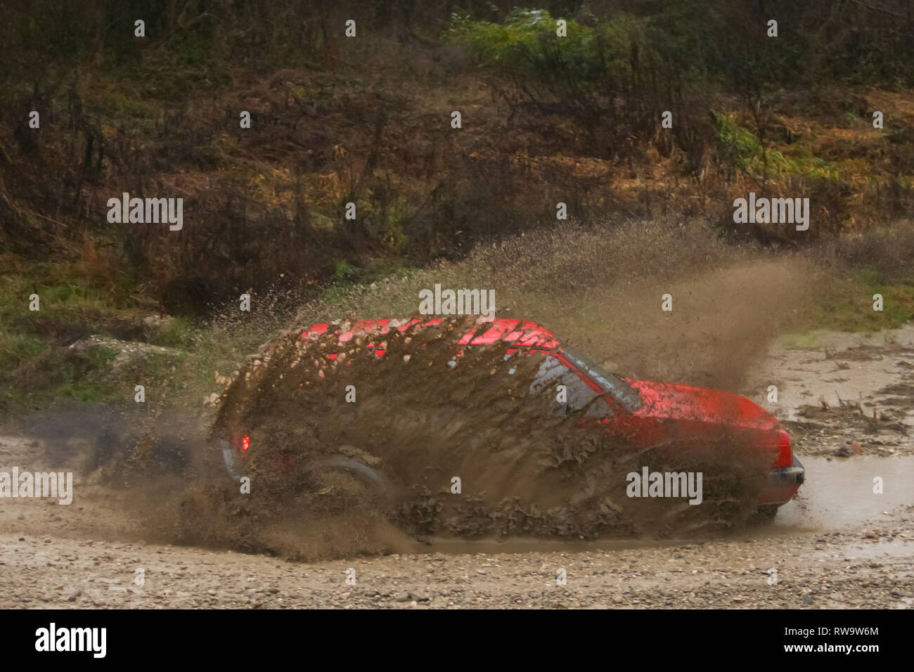 Red rally car driving thru the mud during the race Stock Photo - Alamy