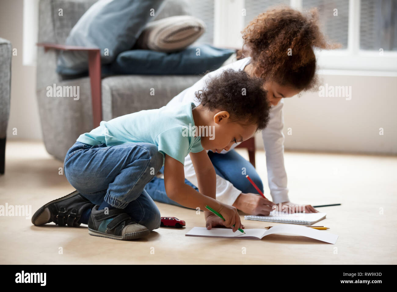 Small black siblings drawing together with colorful pencils Stock Photo ...