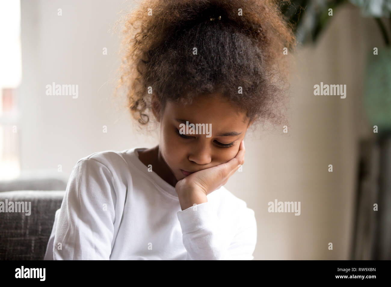 Upset African American girl feel down sitting alone Stock Photo - Alamy