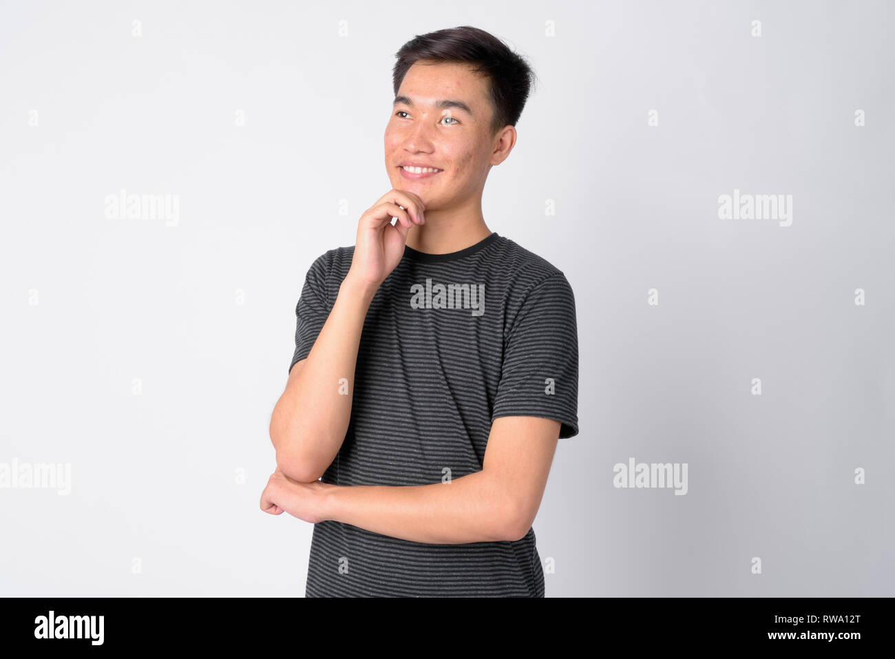 Portrait of young happy Asian man thinking Stock Photo - Alamy