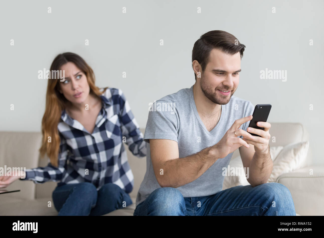 Jealous suspicious wife arguing with obsessed husband holding phone ...