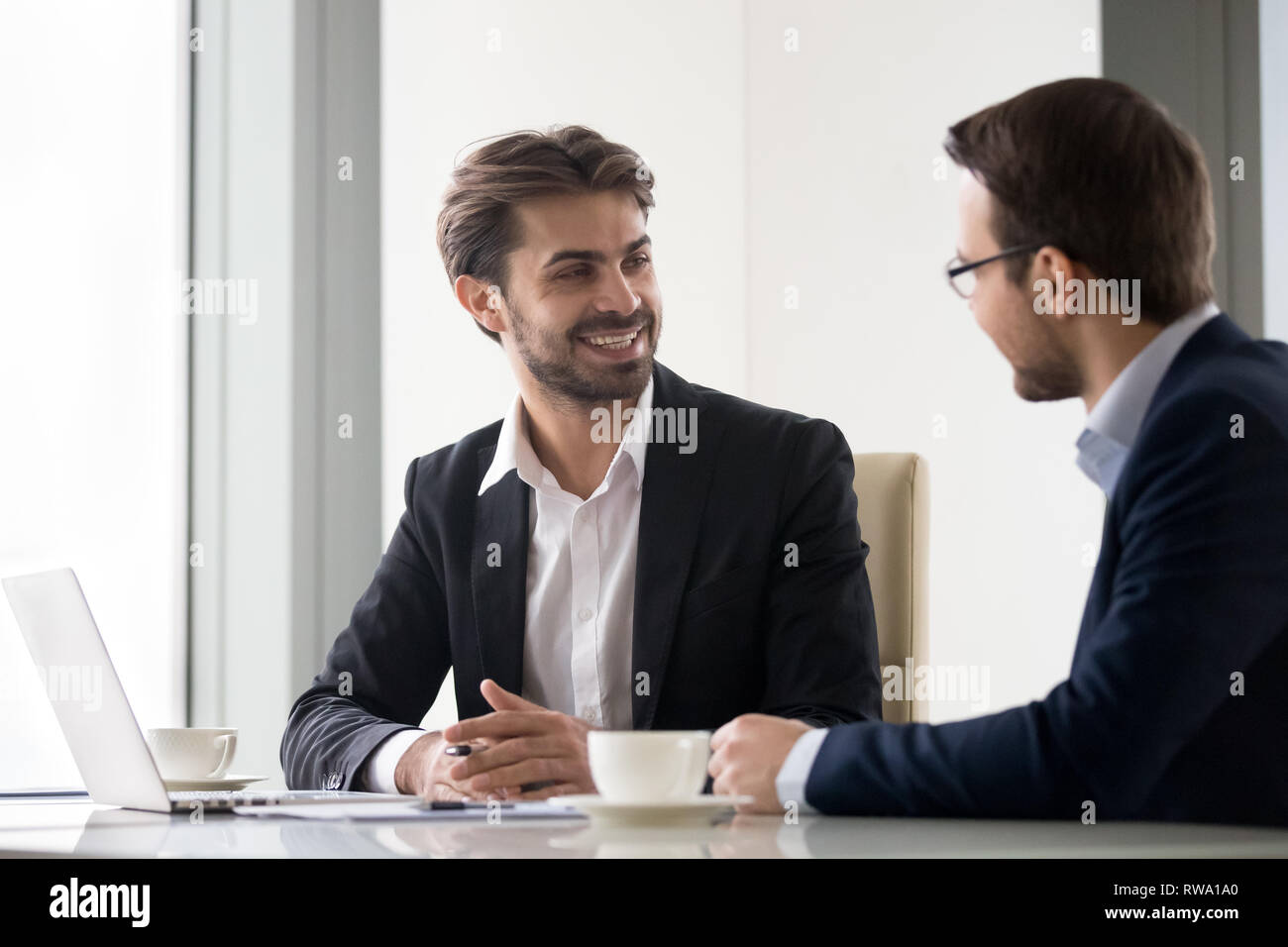 Happy businessmen partners executives talking at work enjoy teamwork ...