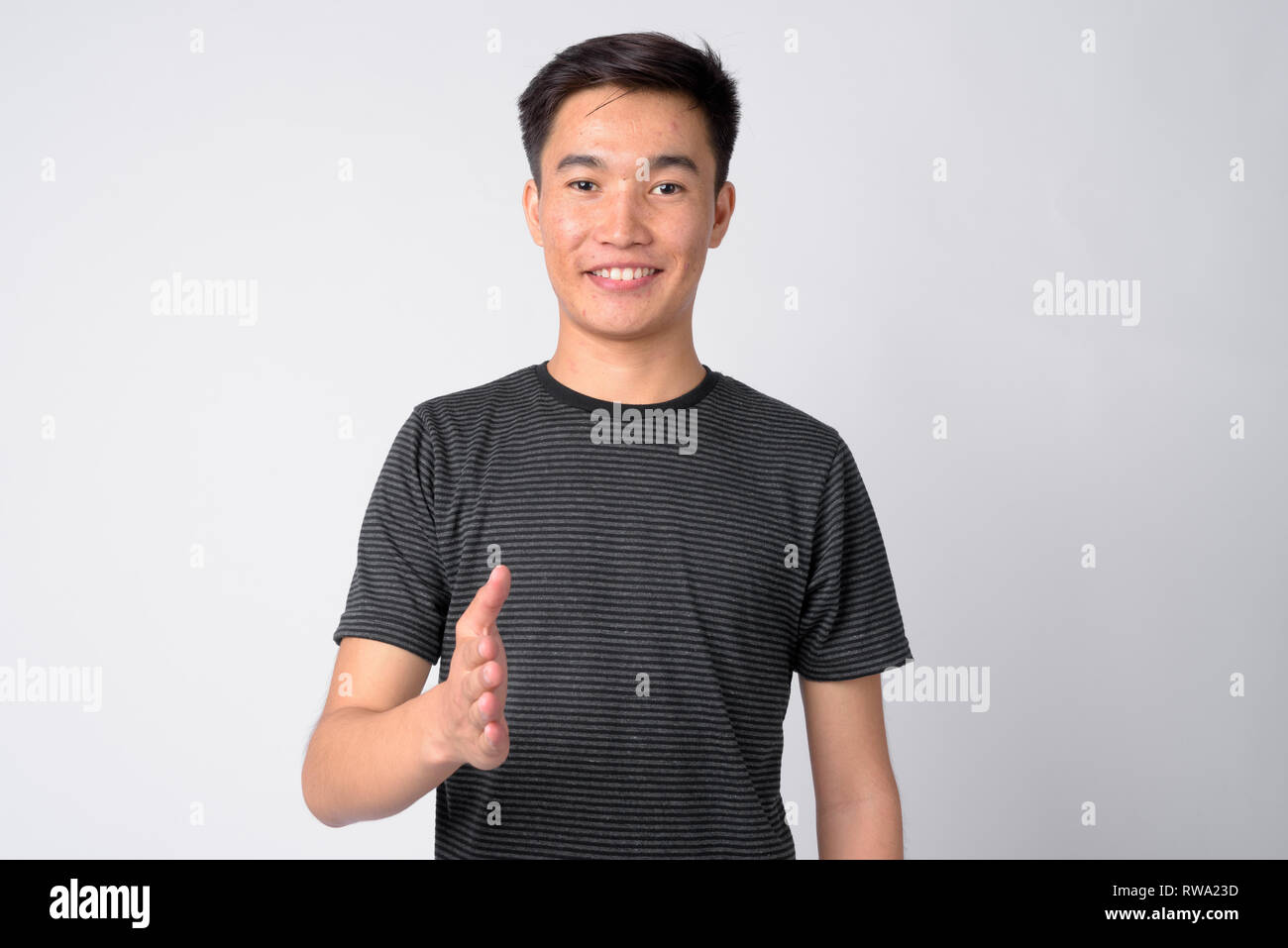 Portrait of young happy Asian man giving handshake Stock Photo - Alamy