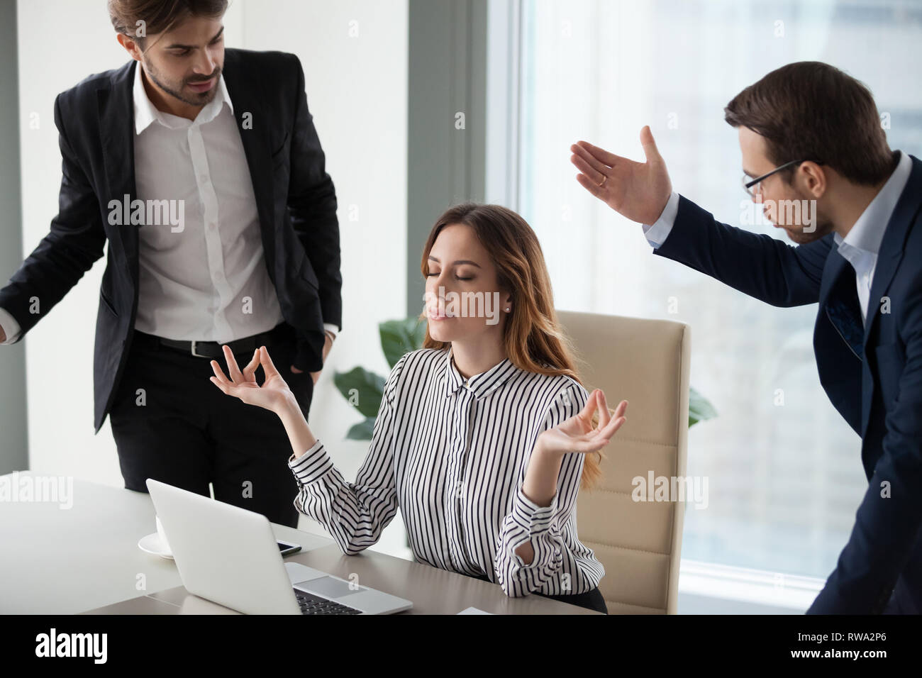 Mindful calm woman boss meditating at work ignoring angry colleagues ...